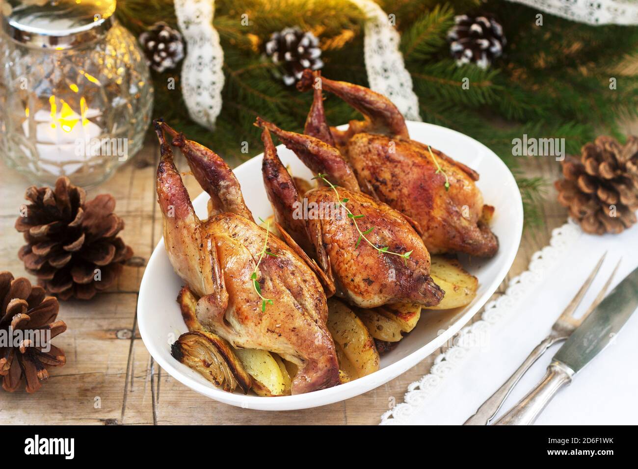Baked quail with potatoes and onions on a festive background. Rustic ...