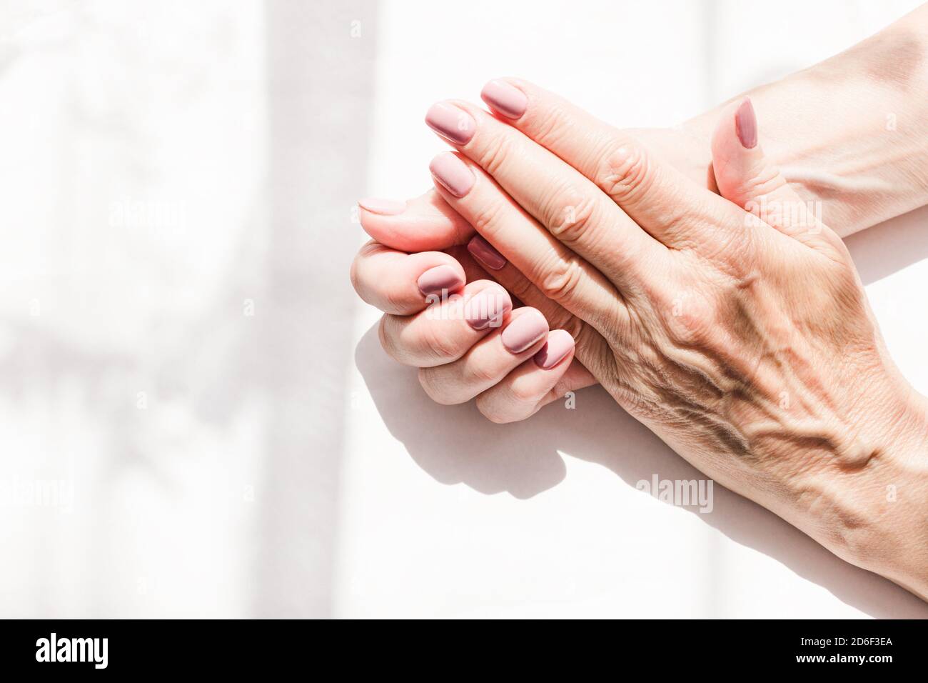 Hands of a senior lady, a woman with a beautiful, natural, pink, beige ...