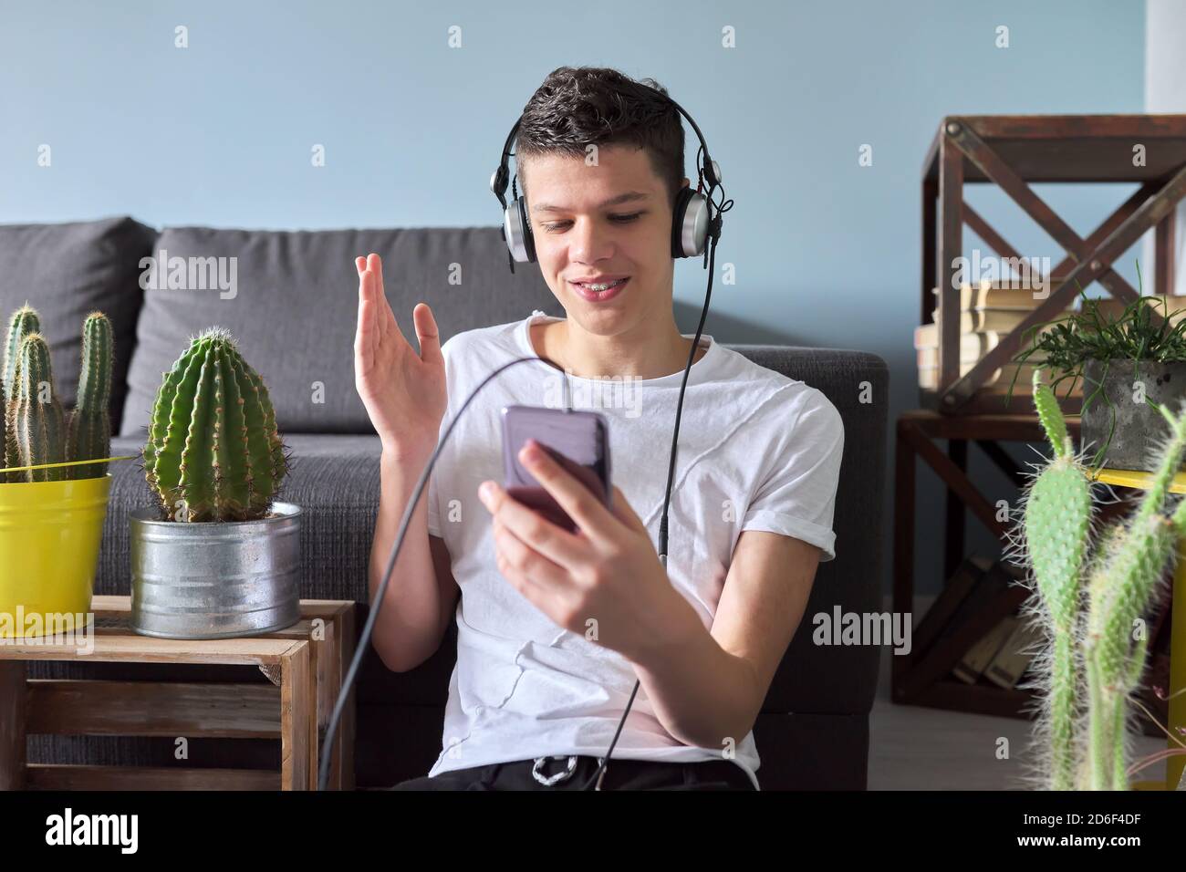 Teenager boy in headphones with smartphone making video call Stock ...