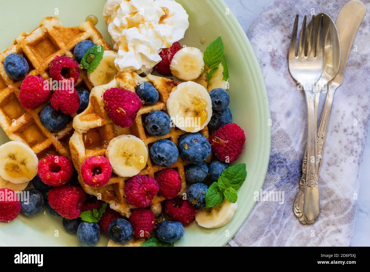 fresh fruit and waffles, ras[berries, blueberries and bananas. close-up ...