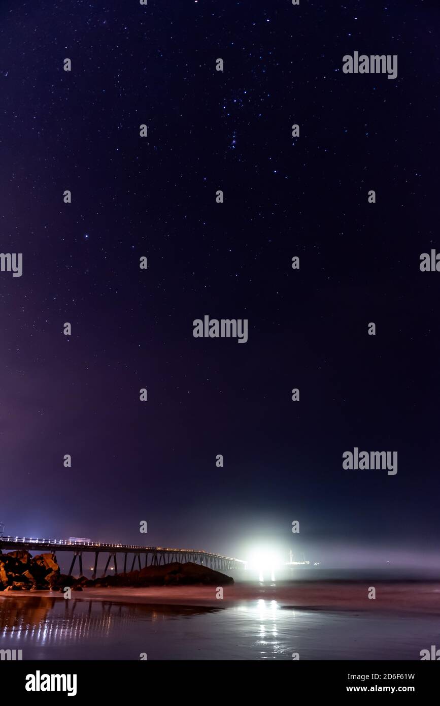 Richfield Pier reflects in the wet sand of Mussel Shoals beach with ...