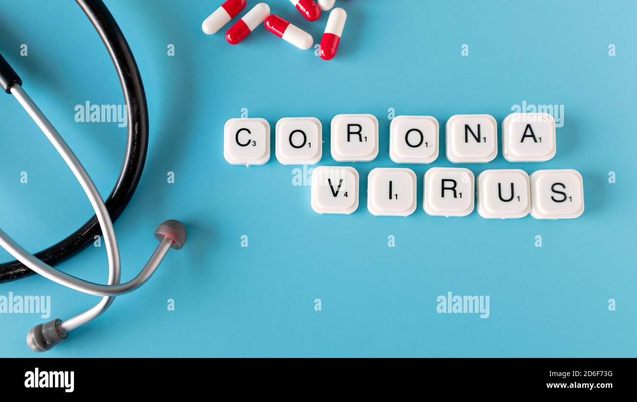 Closeup shot of "Coronavirus" cubic letters, capsule medications, and a ...