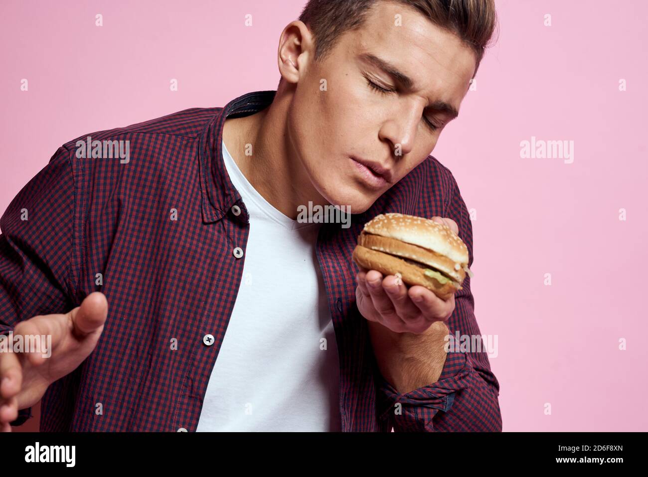 hungry man with hamburgers in hands fast food diet food emotions pink ...