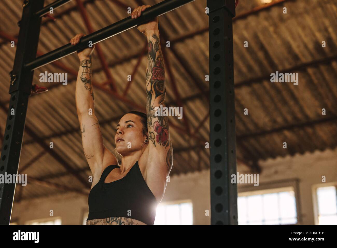 Woman doing pull up workout on horizontal bar. Strong female athlete ...