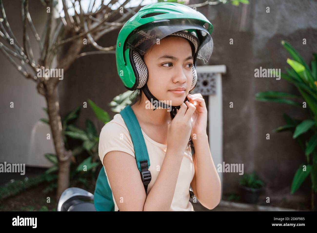 teenage girl close up while wearing and fasten her motorcycle helmet ...