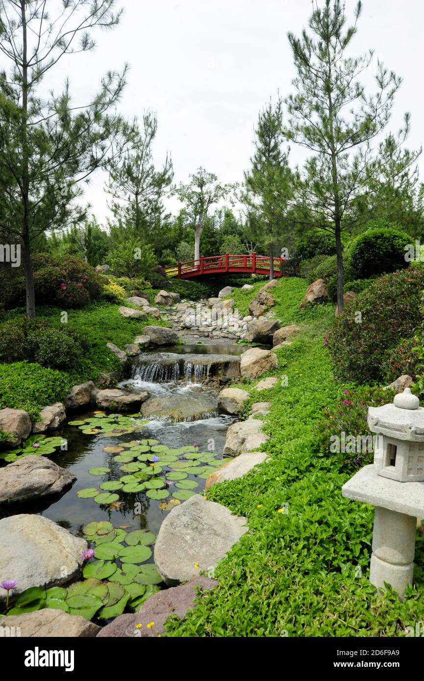 Shot of a red bridge on a tiny river Stock Photo - Alamy