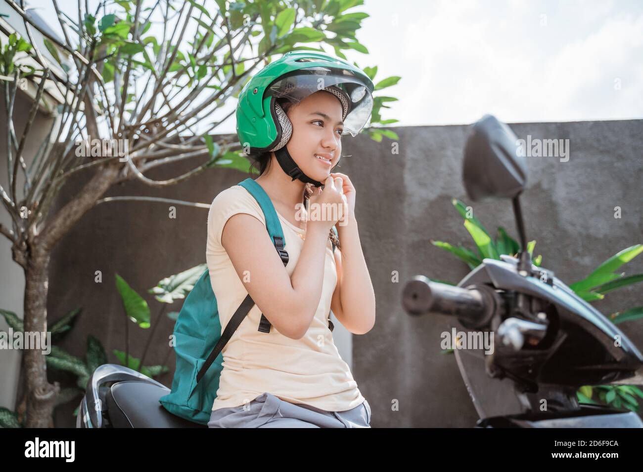 teenage girl close up while wearing and fasten her motorcycle helmet ...