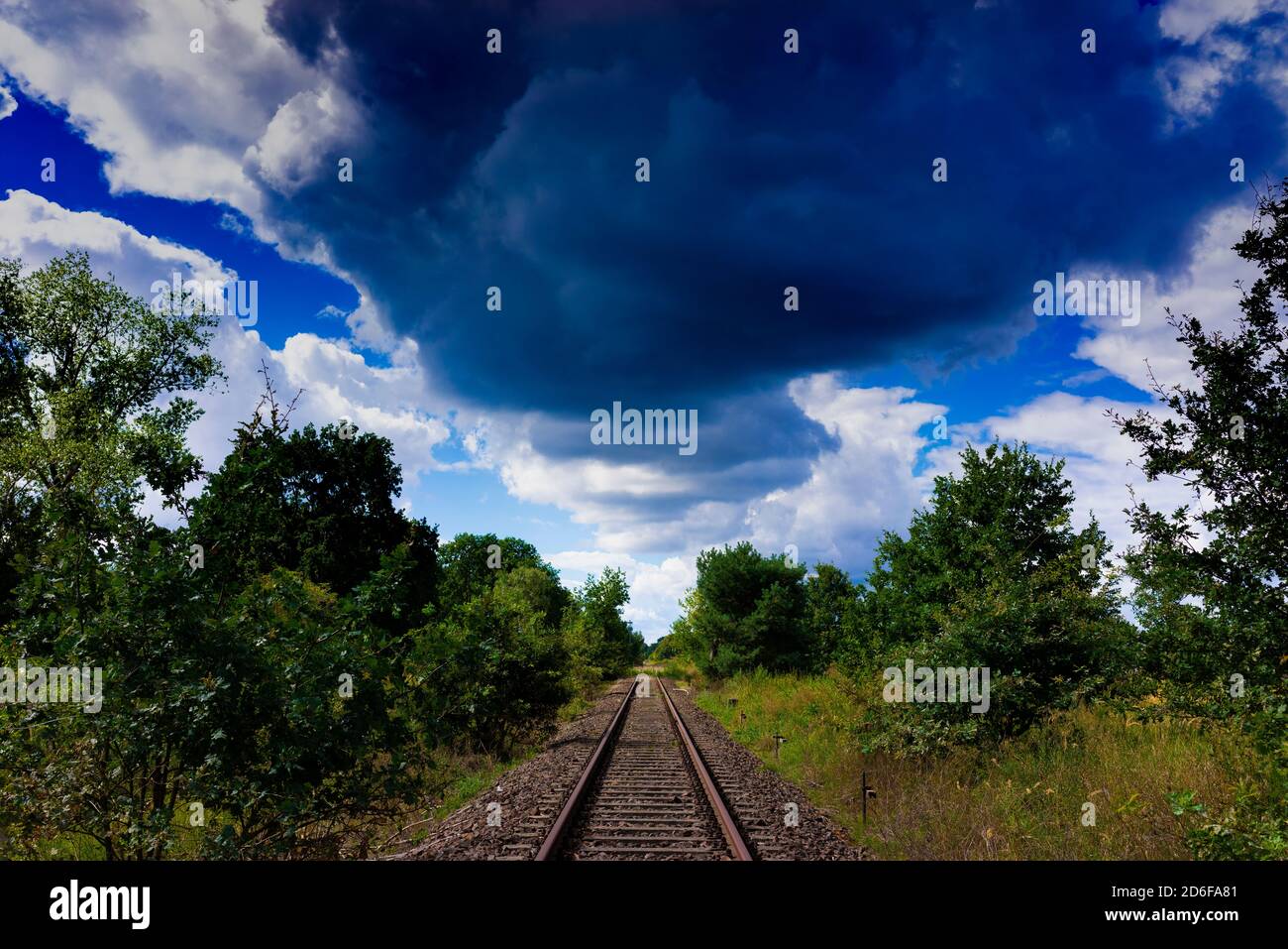 old railway track, with large rain clouds in the sky Stock Photo - Alamy