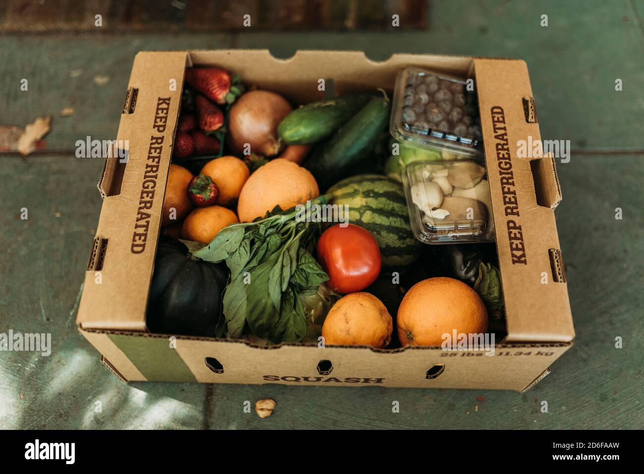 CSA farmers box full of produce on front porch Stock Photo - Alamy