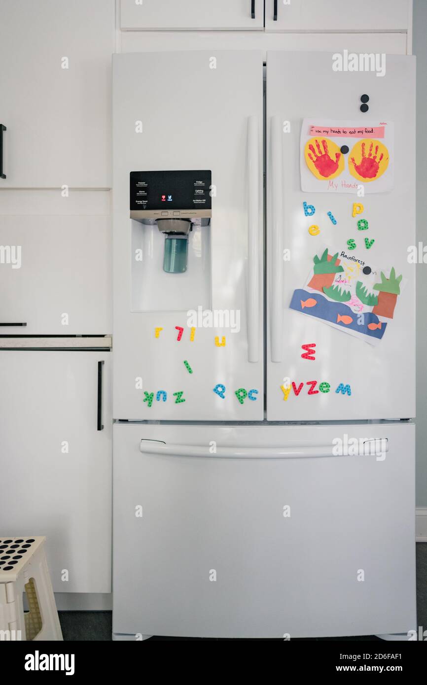 refrigerator with letter magnets and kid artwork Stock Photo - Alamy