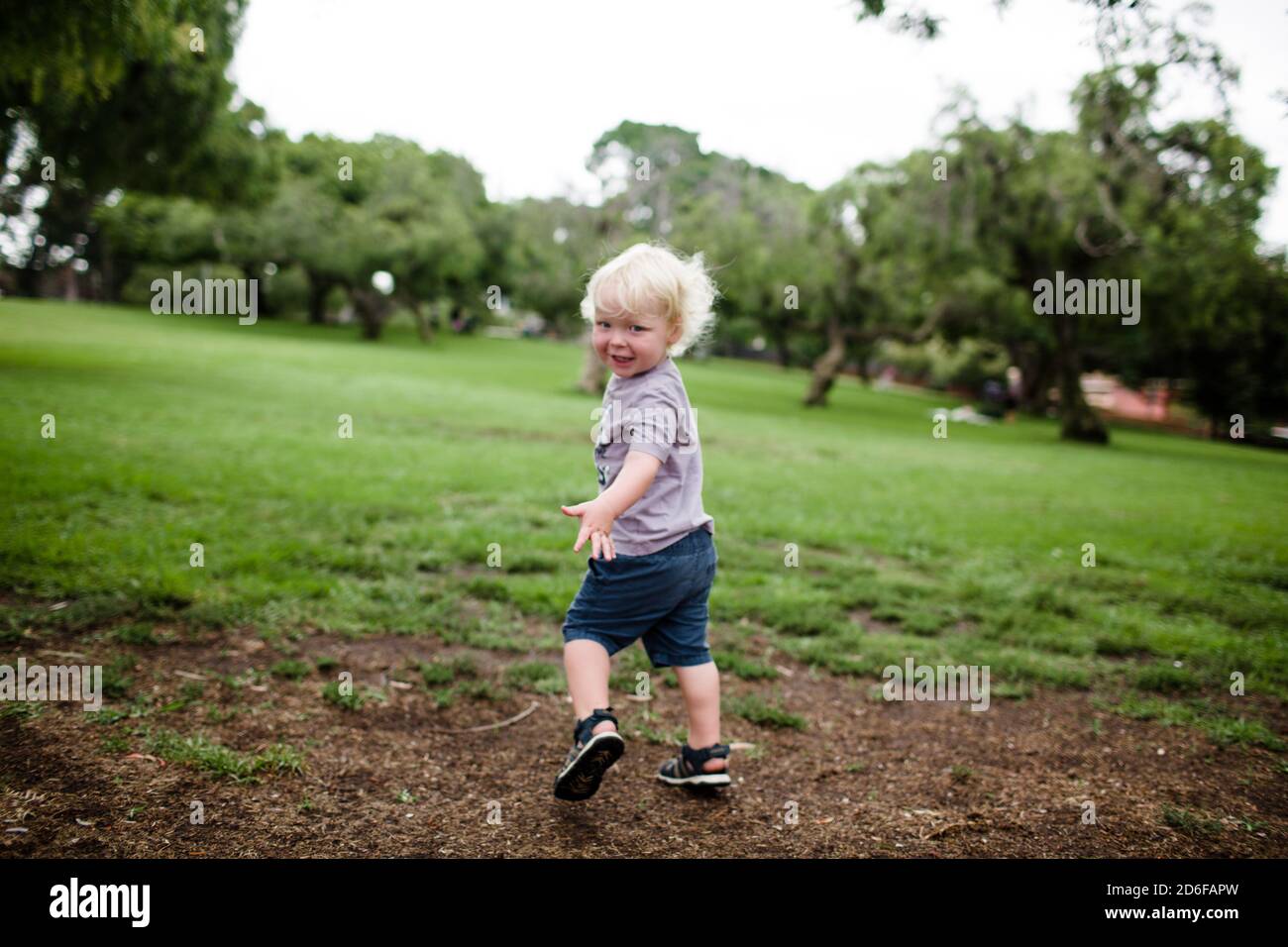 Two Year Old Looking Back at Camera While Running Through Park Stock ...