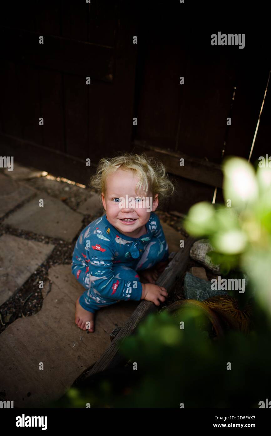 Toddler in Pajamas Smiling for Camera While Crouching in Front Yard ...