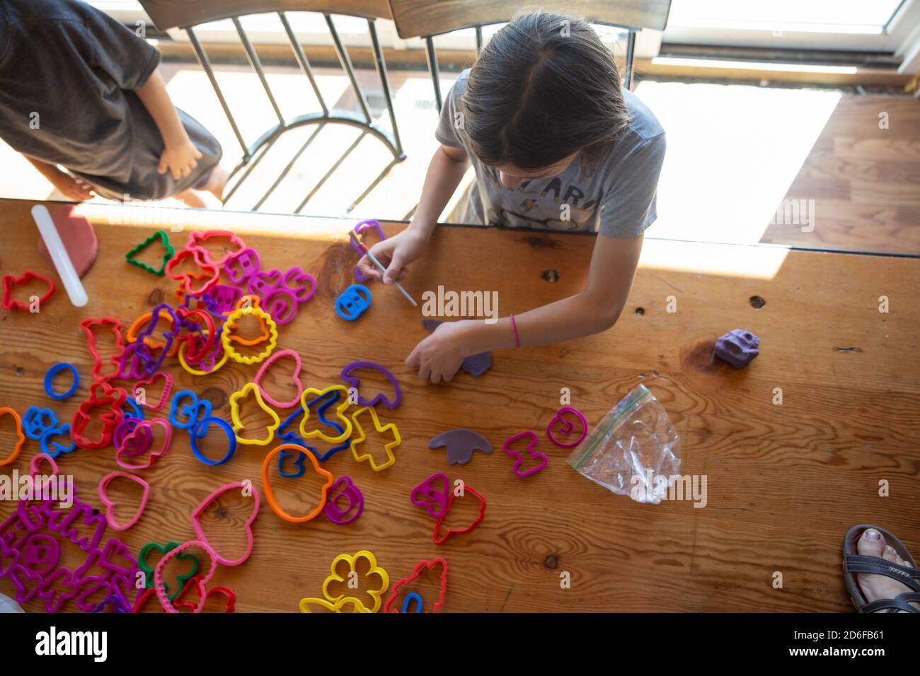 Tween girl playing with colorful cookie cutters Stock Photo - Alamy