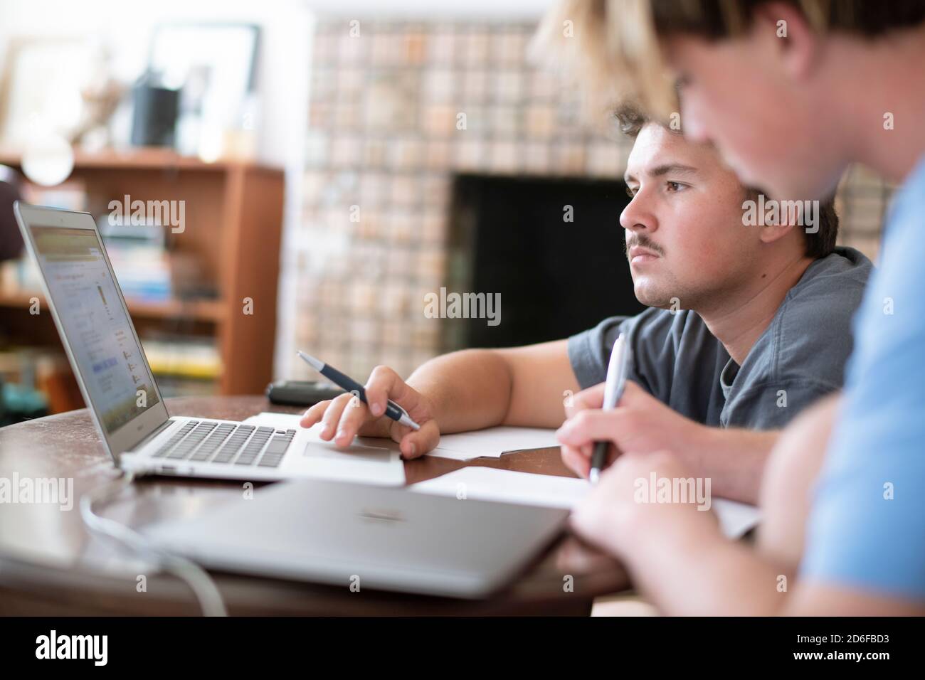 male college students doing schoolwork at home in remote set up Stock ...