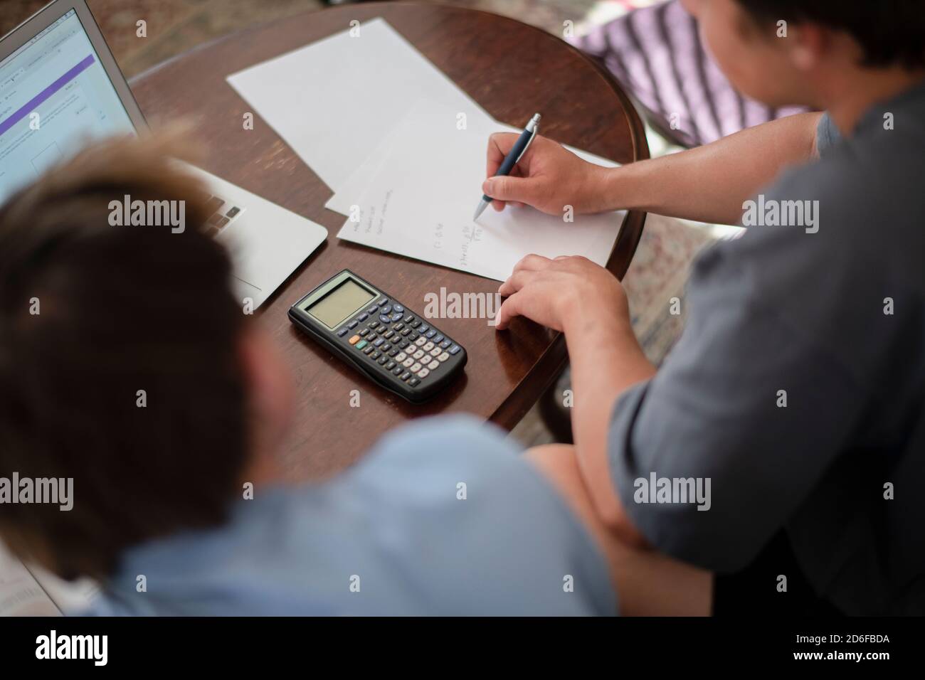 over the shoulder view of 2 teen boys doing math homework Stock Photo ...