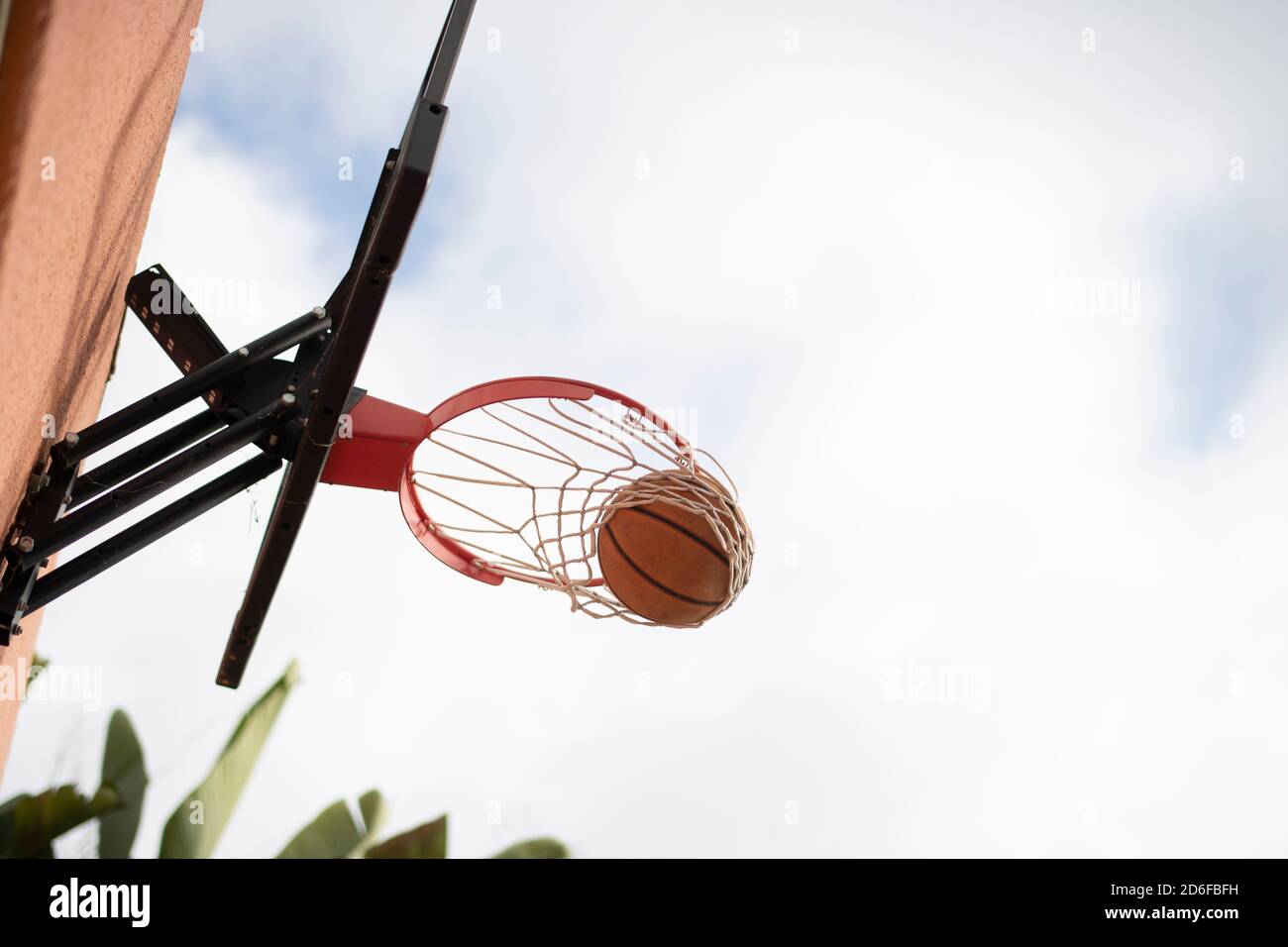 Basketball plunges through net on an outdoor basket Stock Photo - Alamy