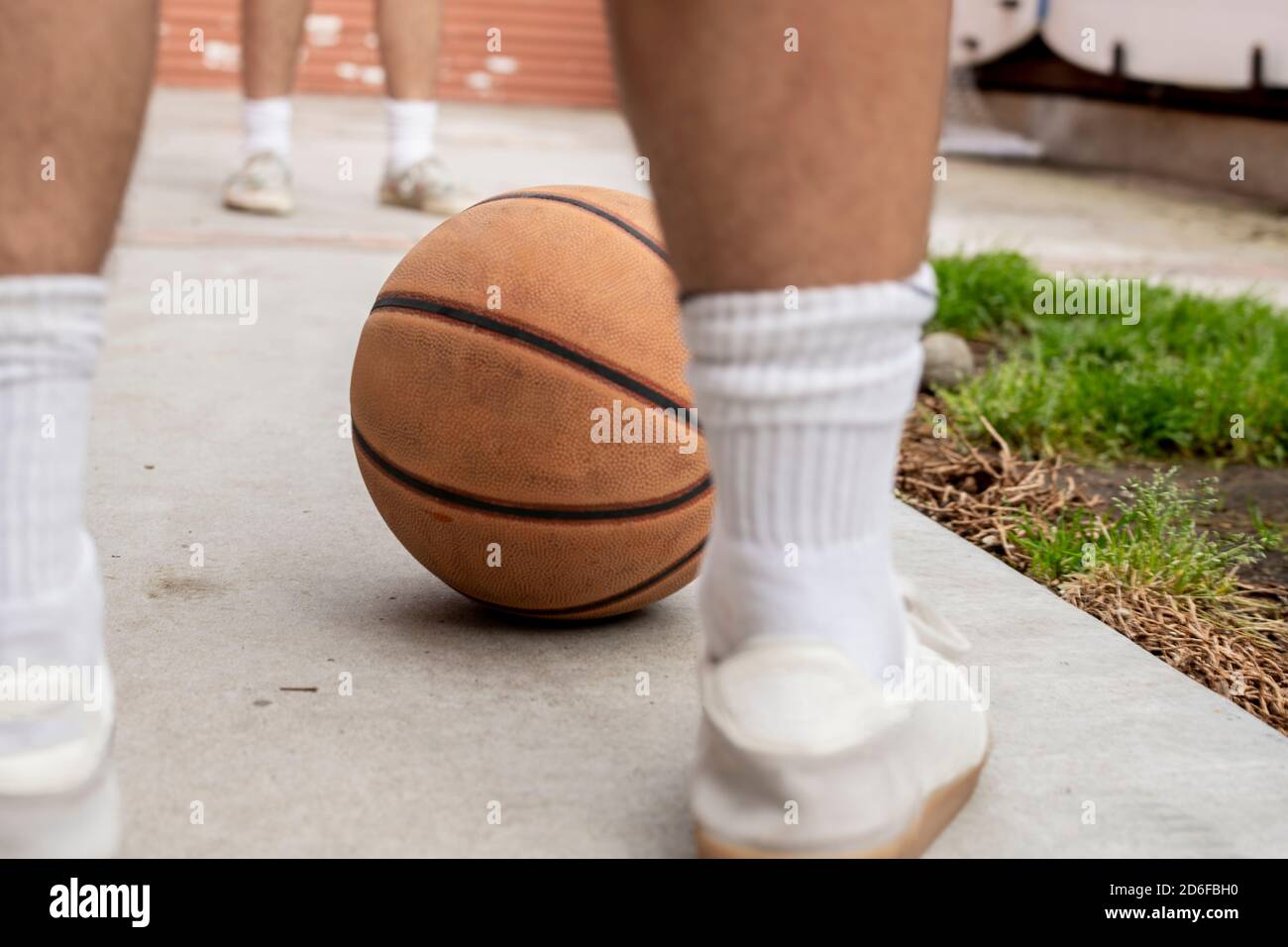ground level view of basketball waiting between young mans legs Stock ...