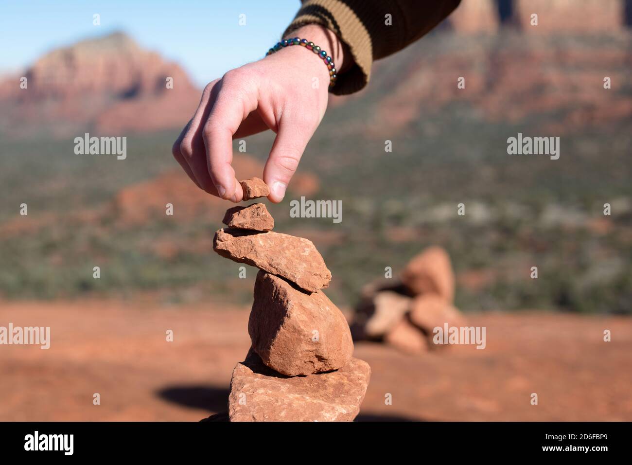 hand balancing red stone on a rock tower in Sedona Arizona Stock Photo ...