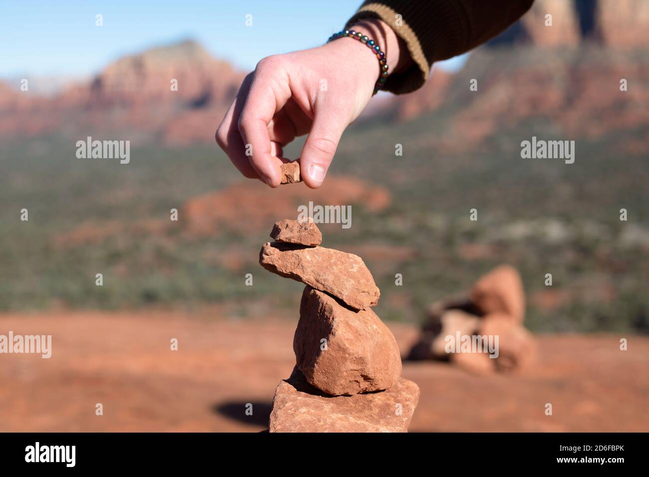 hand balancing red stone on a rock tower in Sedona Arizona Stock Photo ...