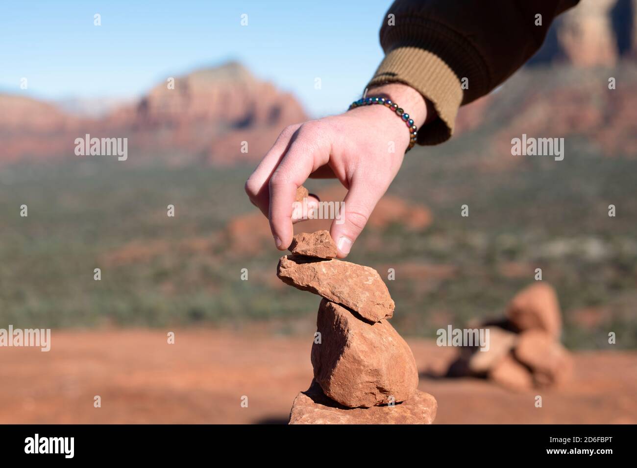 hand balancing red stone on a rock tower in Sedona Arizona Stock Photo ...