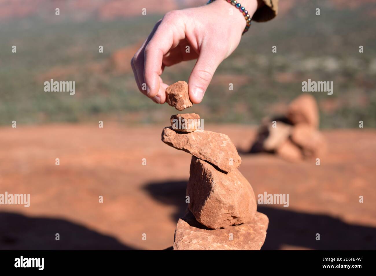 hand balancing red stone on a rock tower in Sedona Arizona Stock Photo ...
