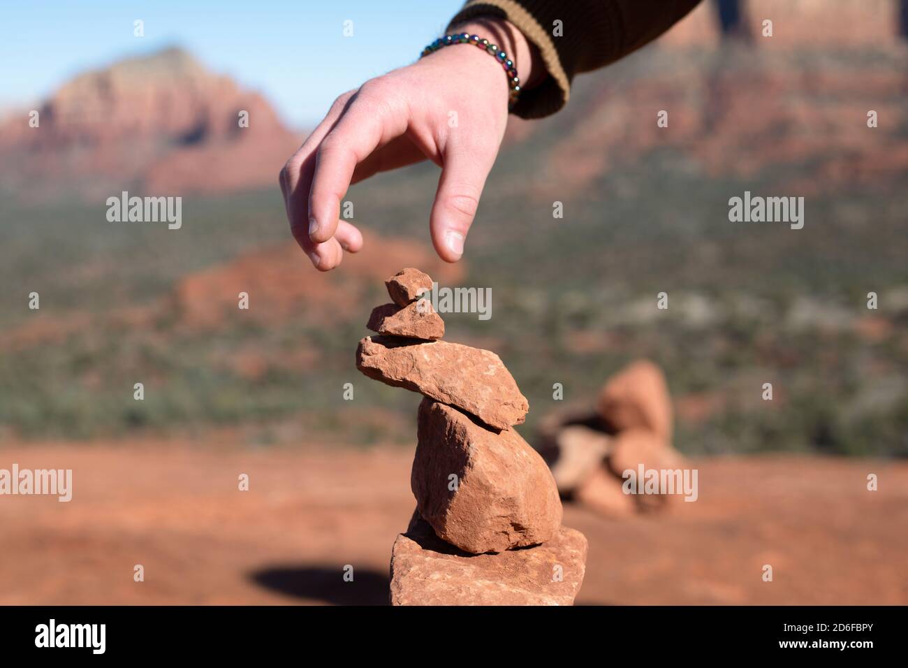 hand balancing red stone on a rock tower in Sedona Arizona Stock Photo ...