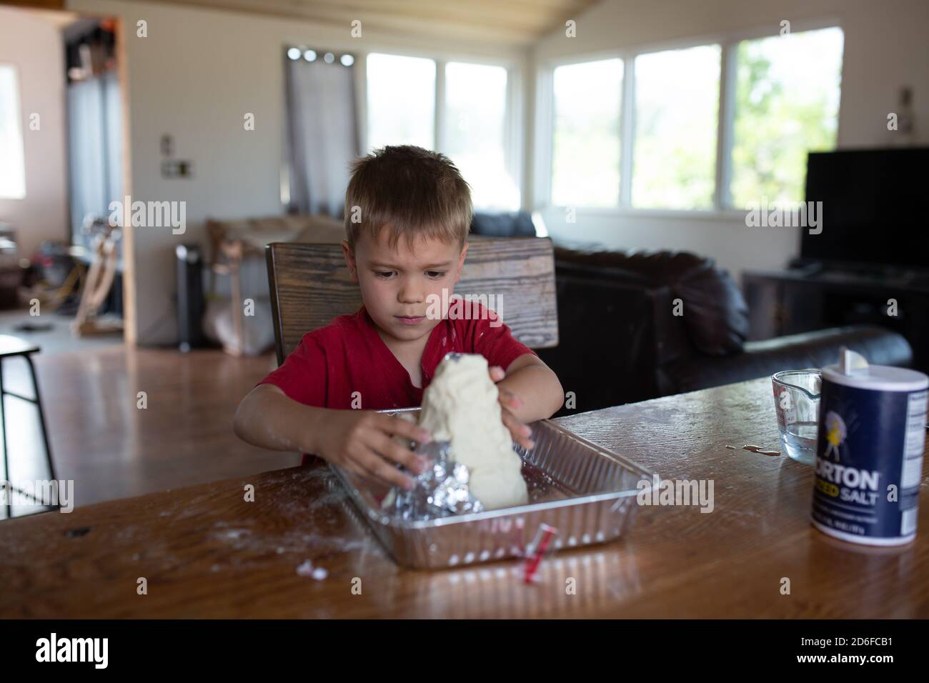 Little boy making clay volcano at kitchen table Stock Photo - Alamy