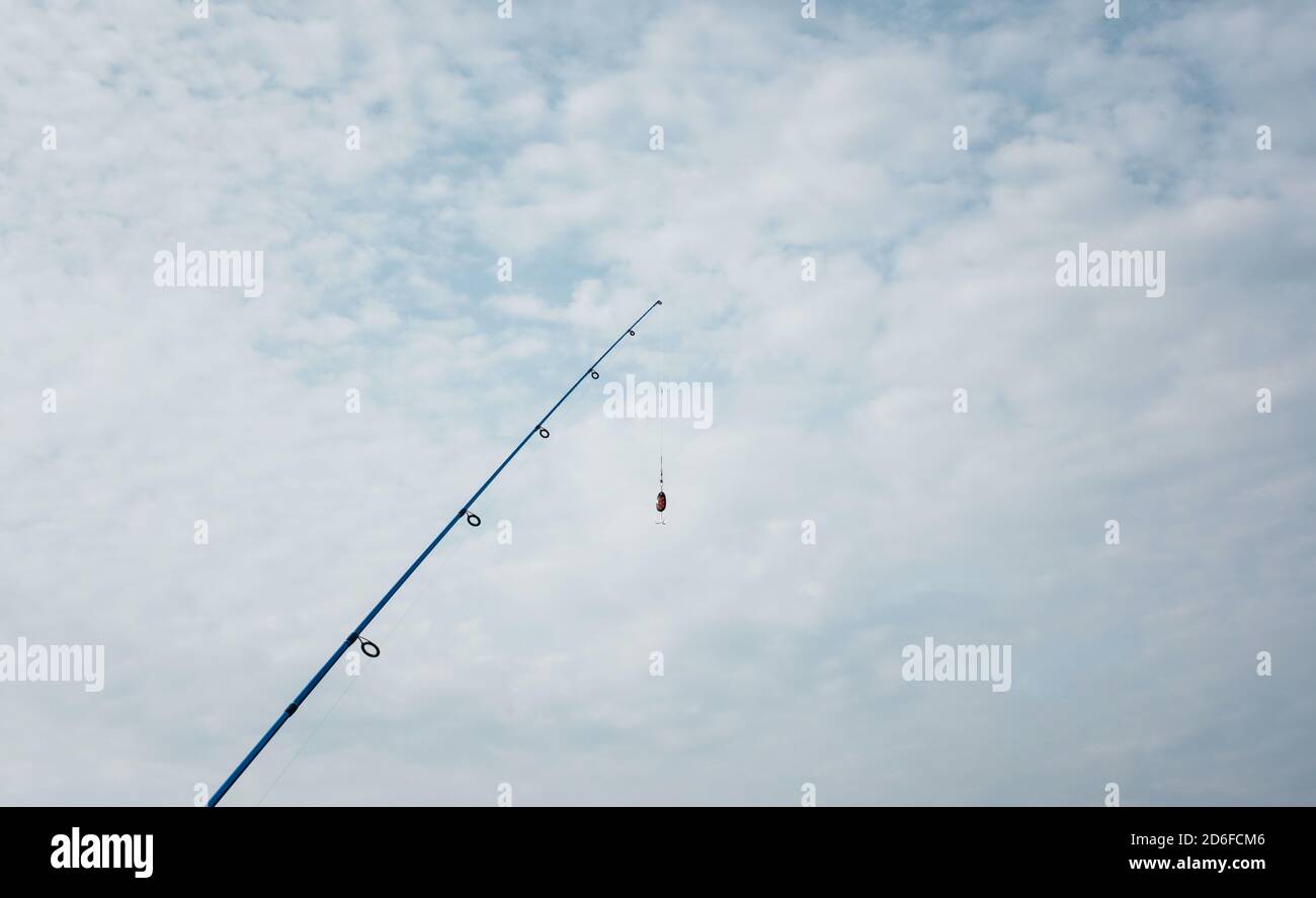 one fishing rod hanging off a pier Stock Photo - Alamy
