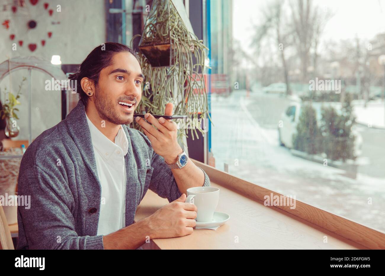 Portrait of a man using the voice recognition of the cell phone and ...