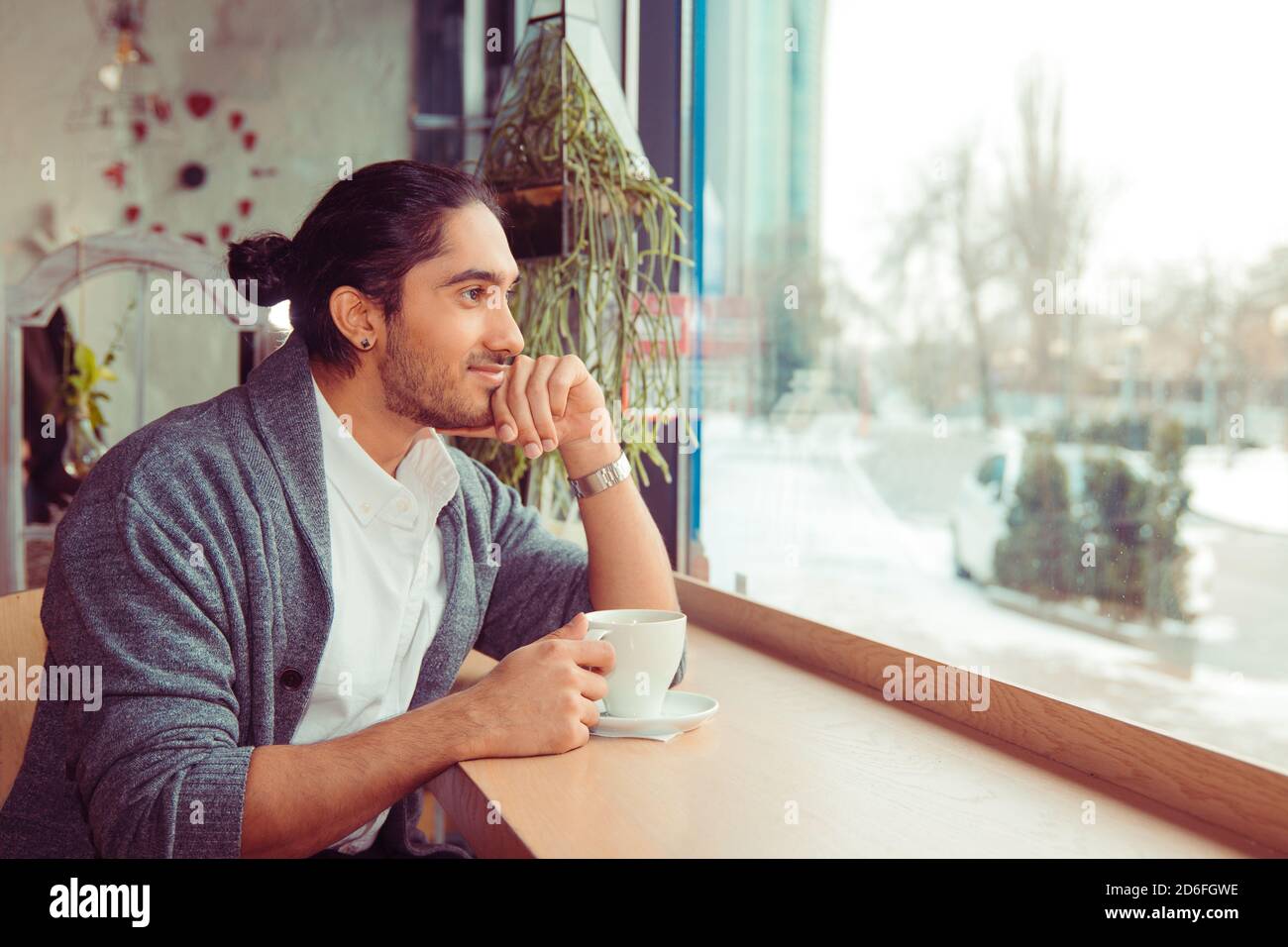 Thoughtful man at trendy coffee shop juice bar restaurant. Young model ...