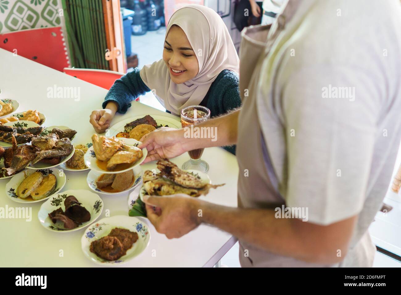 a man give a dish traditional food to woman Stock Photo - Alamy