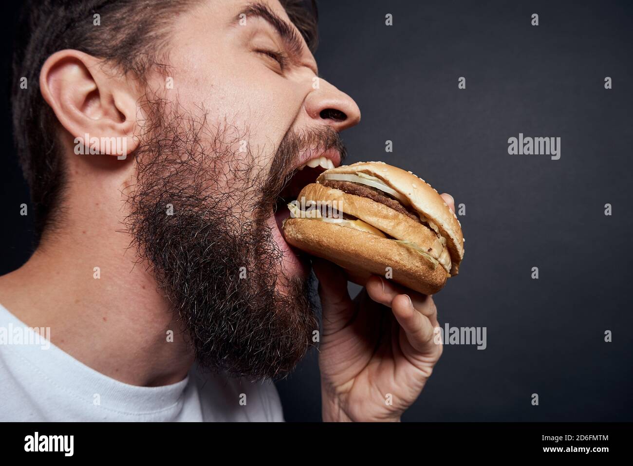 Man eating hamburger fast food restaurant Gourmet eating dark ...