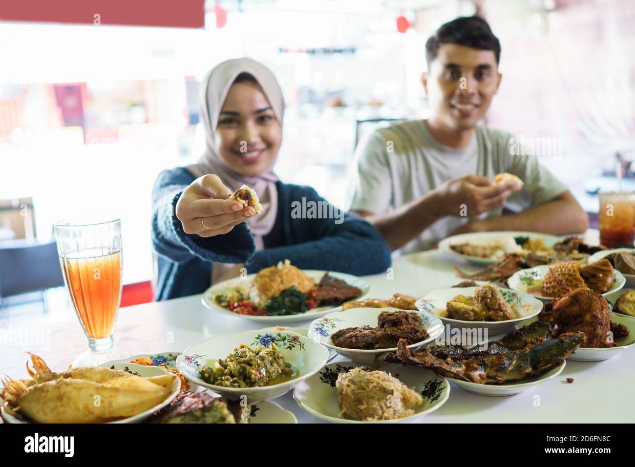 portrait of the couple young eating dish padang food Stock Photo - Alamy