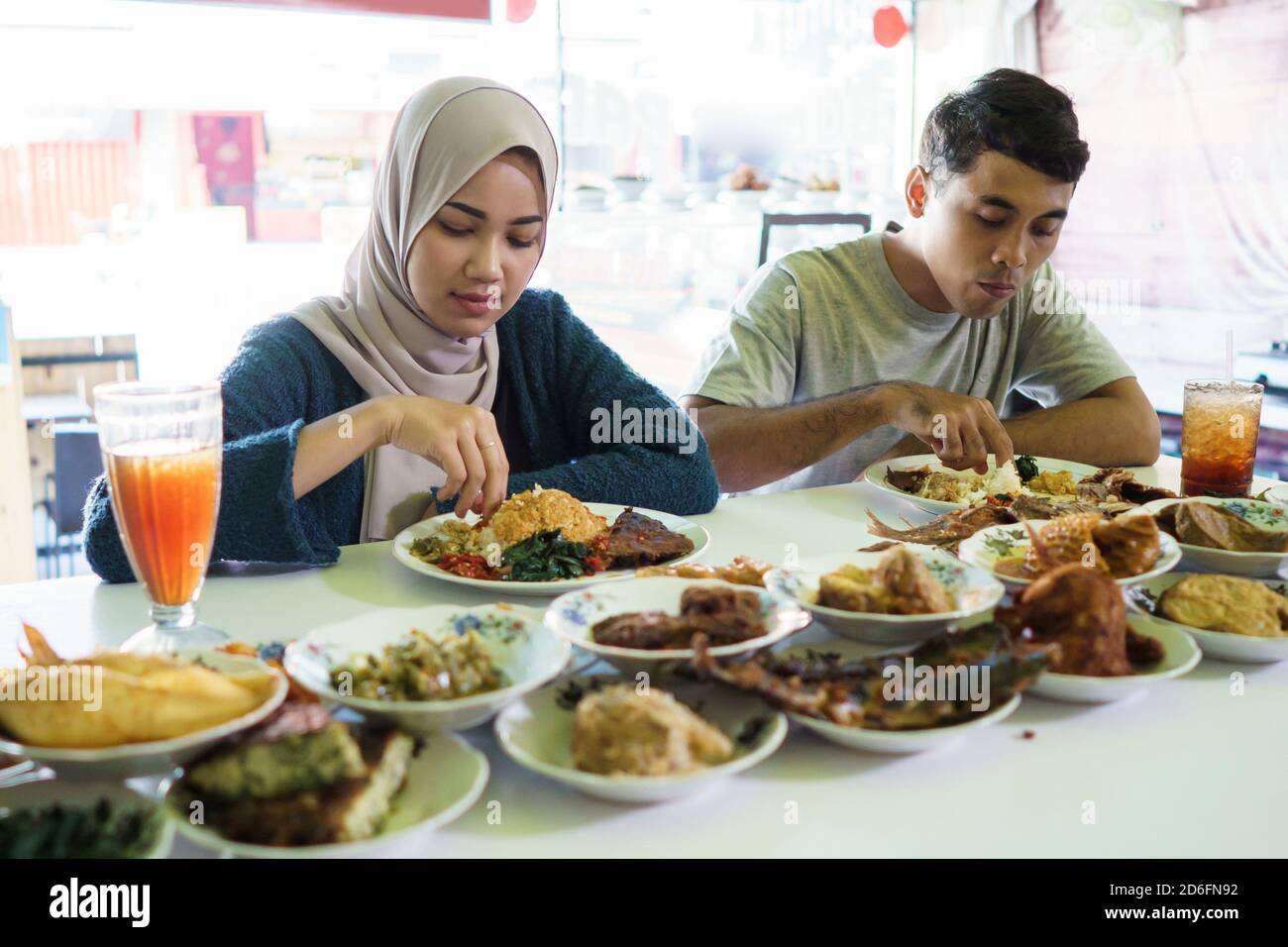 portrait of the couple young eating dish padang food Stock Photo - Alamy
