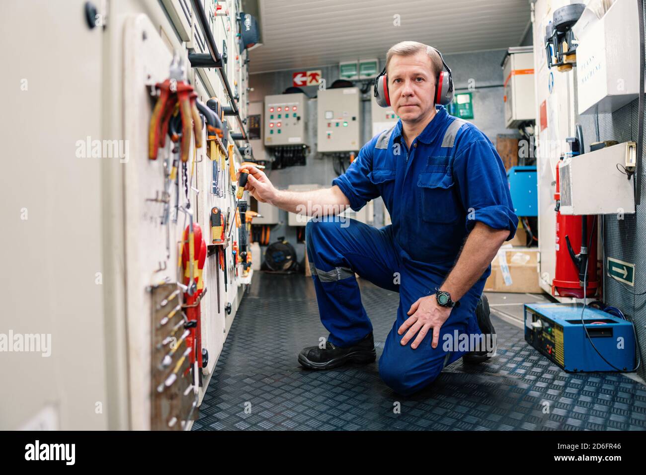 Marine engineer officer in engine control room ECR. He works in ...
