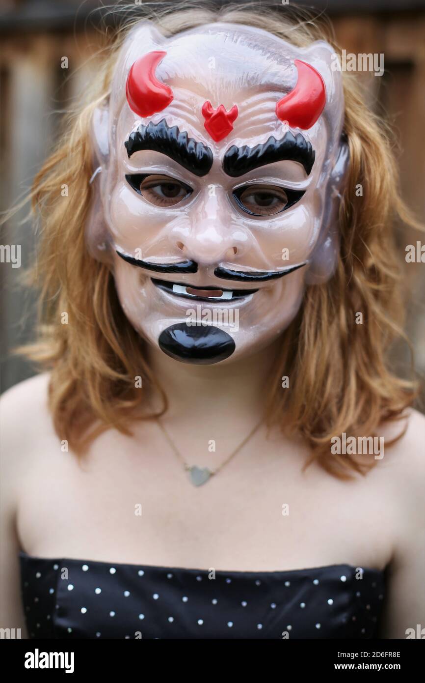 Close up of a teen girl wearing a devil mask Stock Photo - Alamy