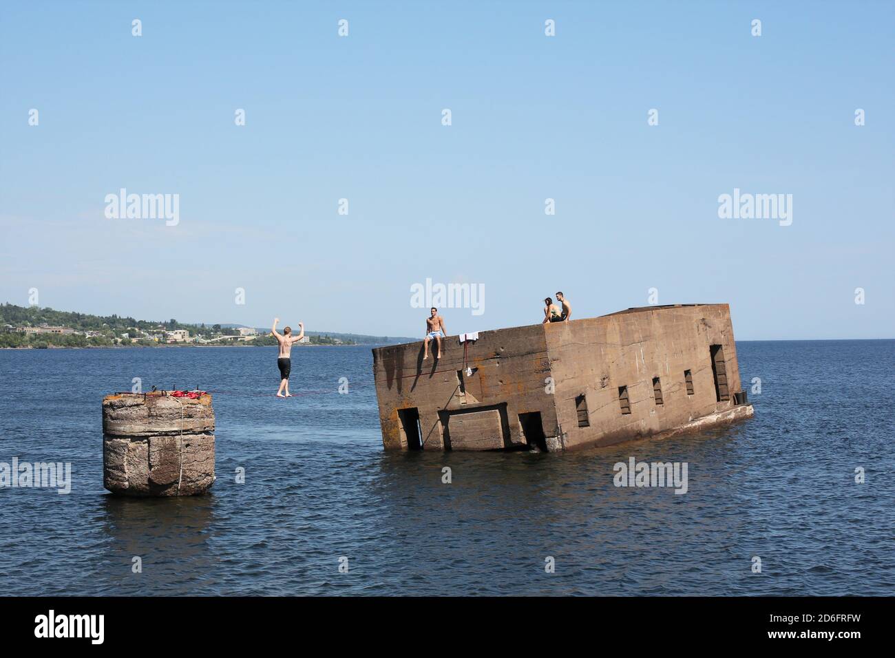 Young people walking a slack rope strung between two structures in Lake ...