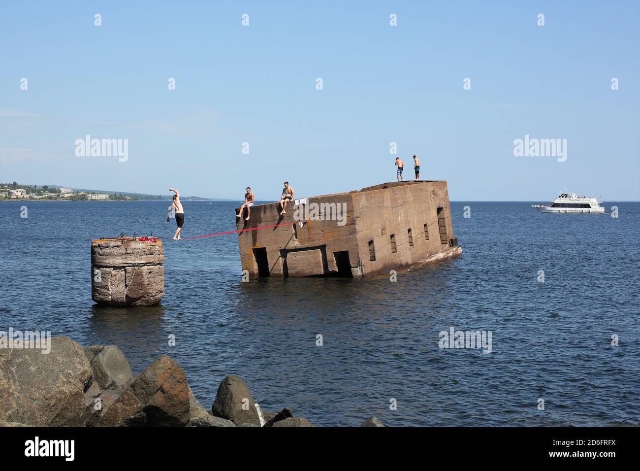 Young people walking a slack rope strung between two structures in Lake ...