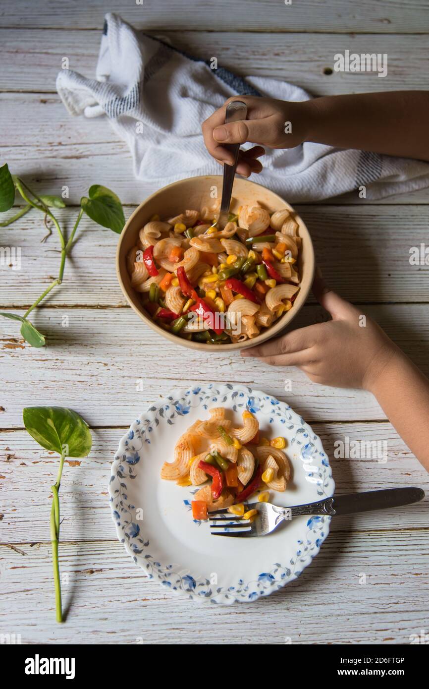 Hands serving pasta Stock Photo - Alamy