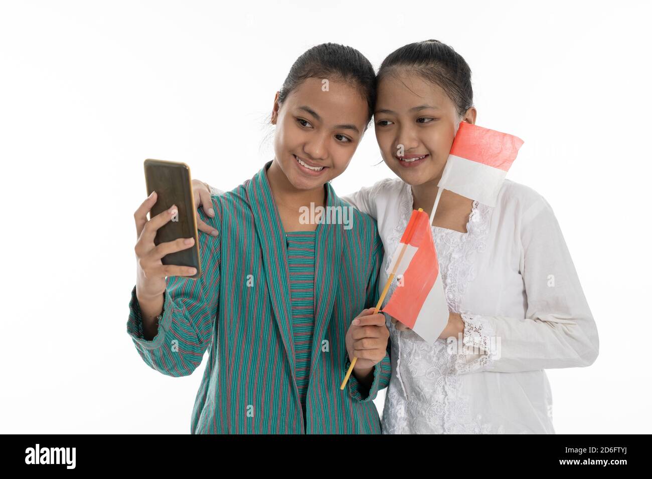 two teenager with indonesian kebaya using mobile phone together taking ...