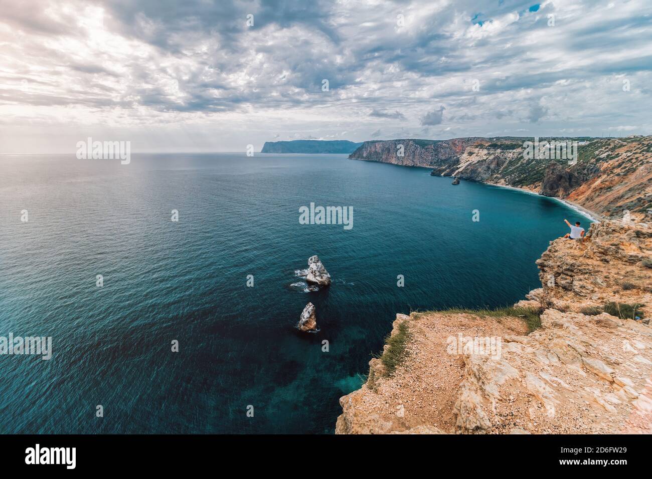 Young man traveler enjoys Autumn seascape with overcast sky and ...