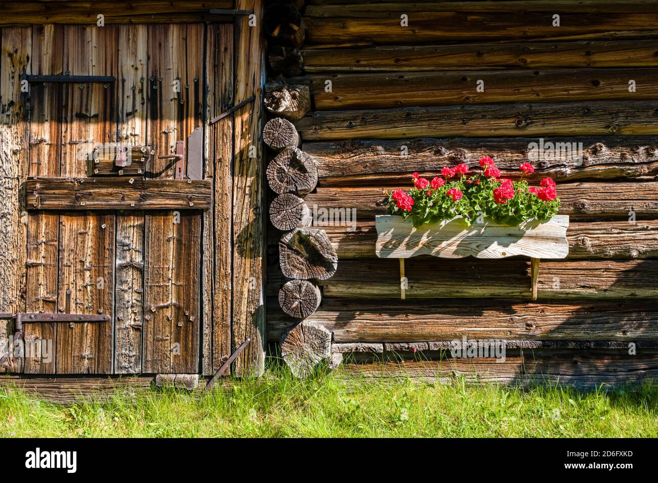 Detail of a wooden house in hilly agricultural countryside with green ...