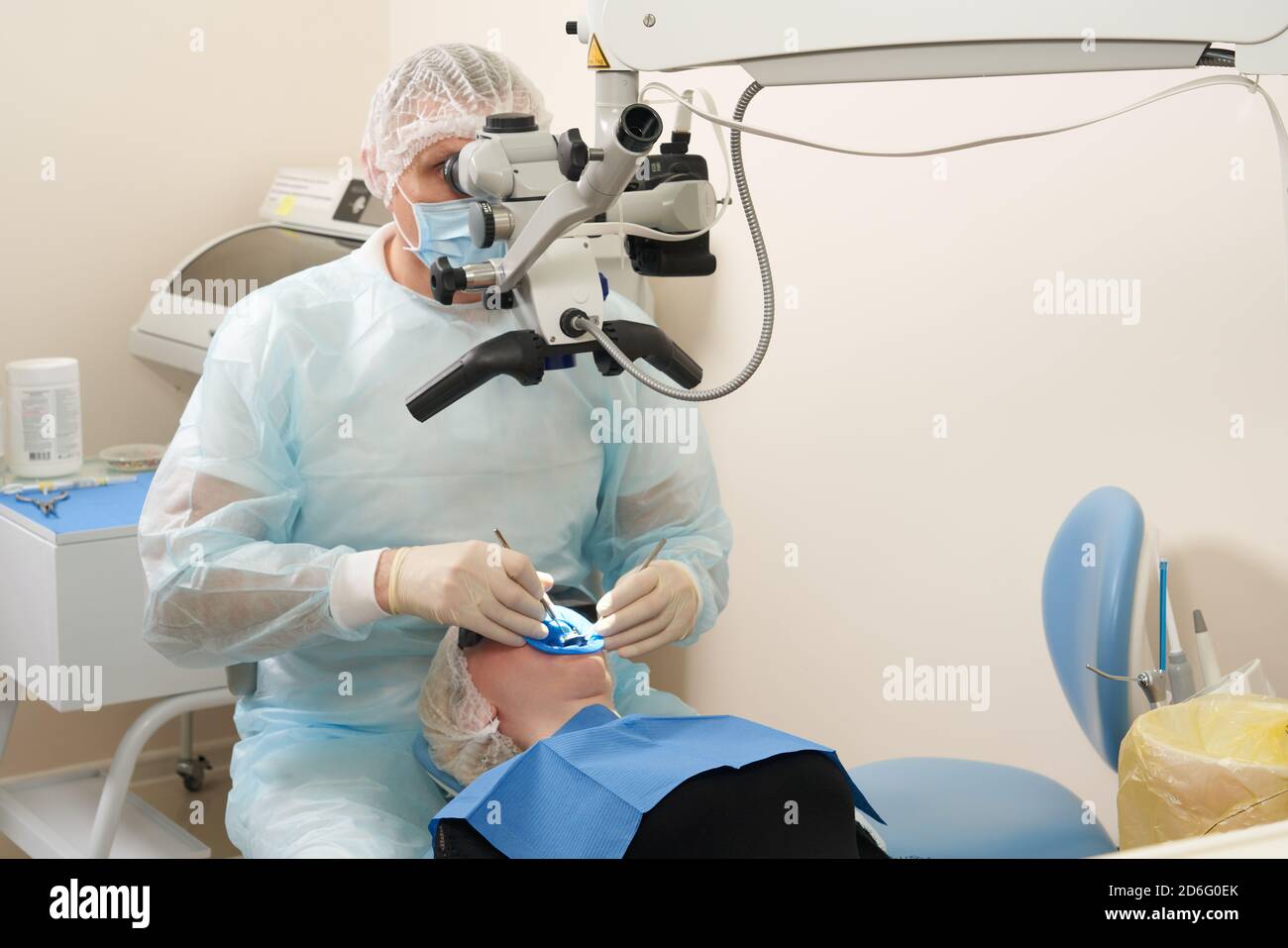 Dentist working with dental microscope and patient at modern dentist ...
