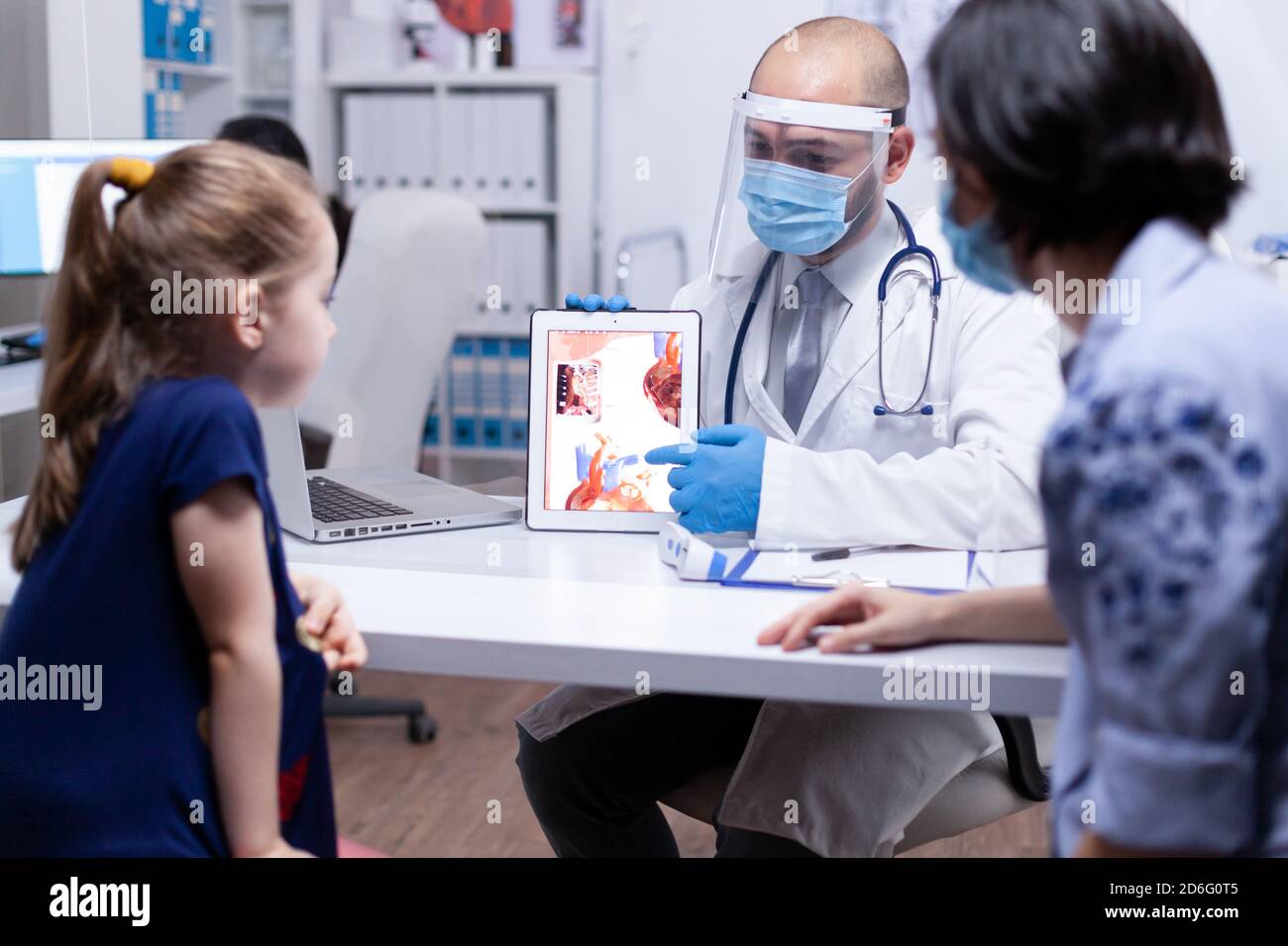 Doctor explaining to child the functions of heart using tablet and ...