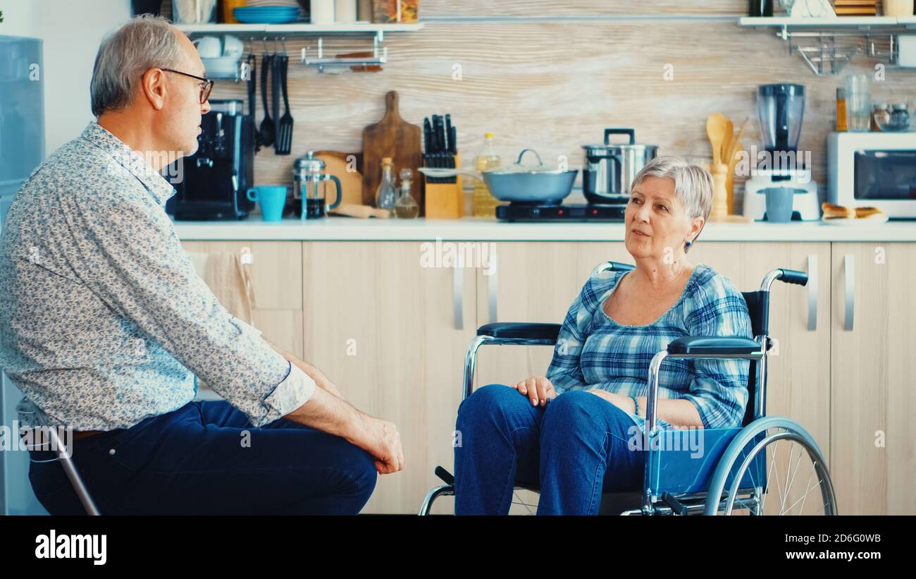 Retired invalid woman in wheelchair having a conversation with old ...