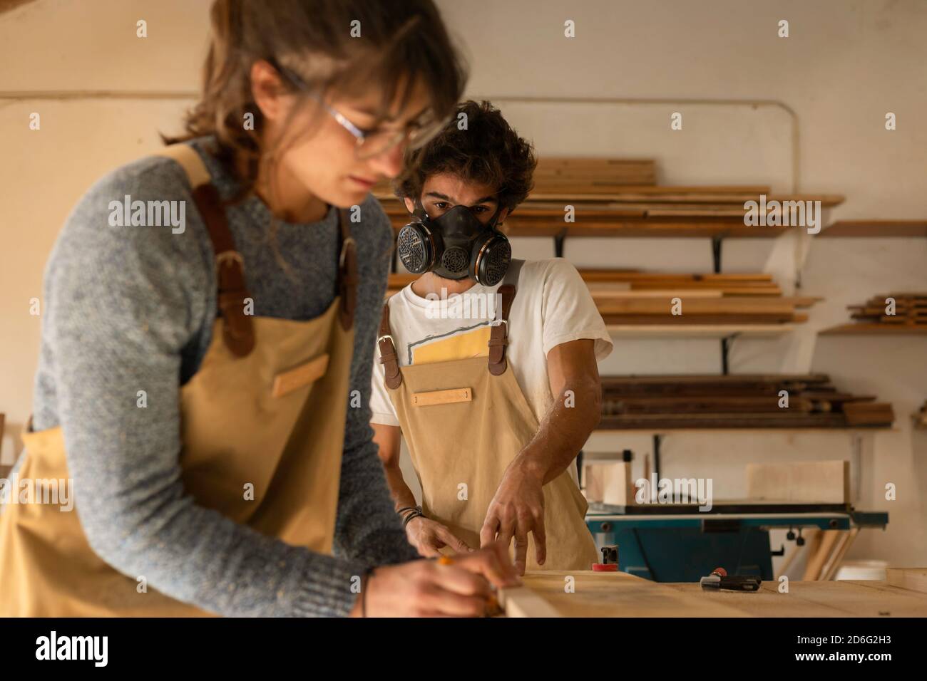 A young couple of carpenters working together in a small carpentry ...