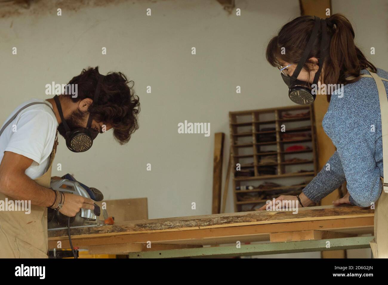 A young couple of carpenters working together in a small carpentry ...