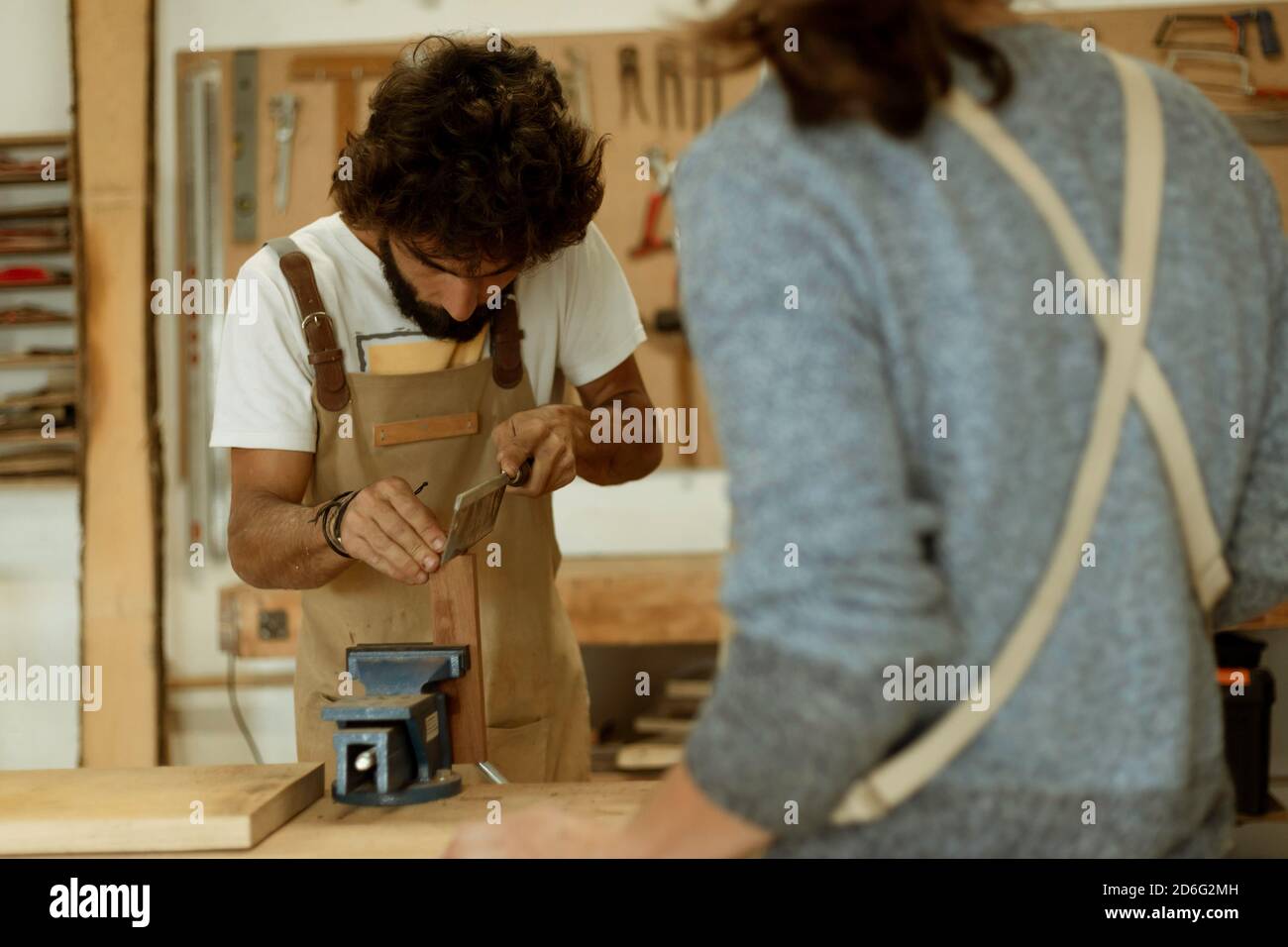 Young business woman working as carpenter in a small carpentry workshop ...