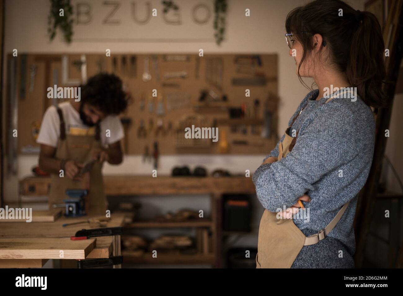 Young business woman working as carpenter in a small carpentry workshop ...