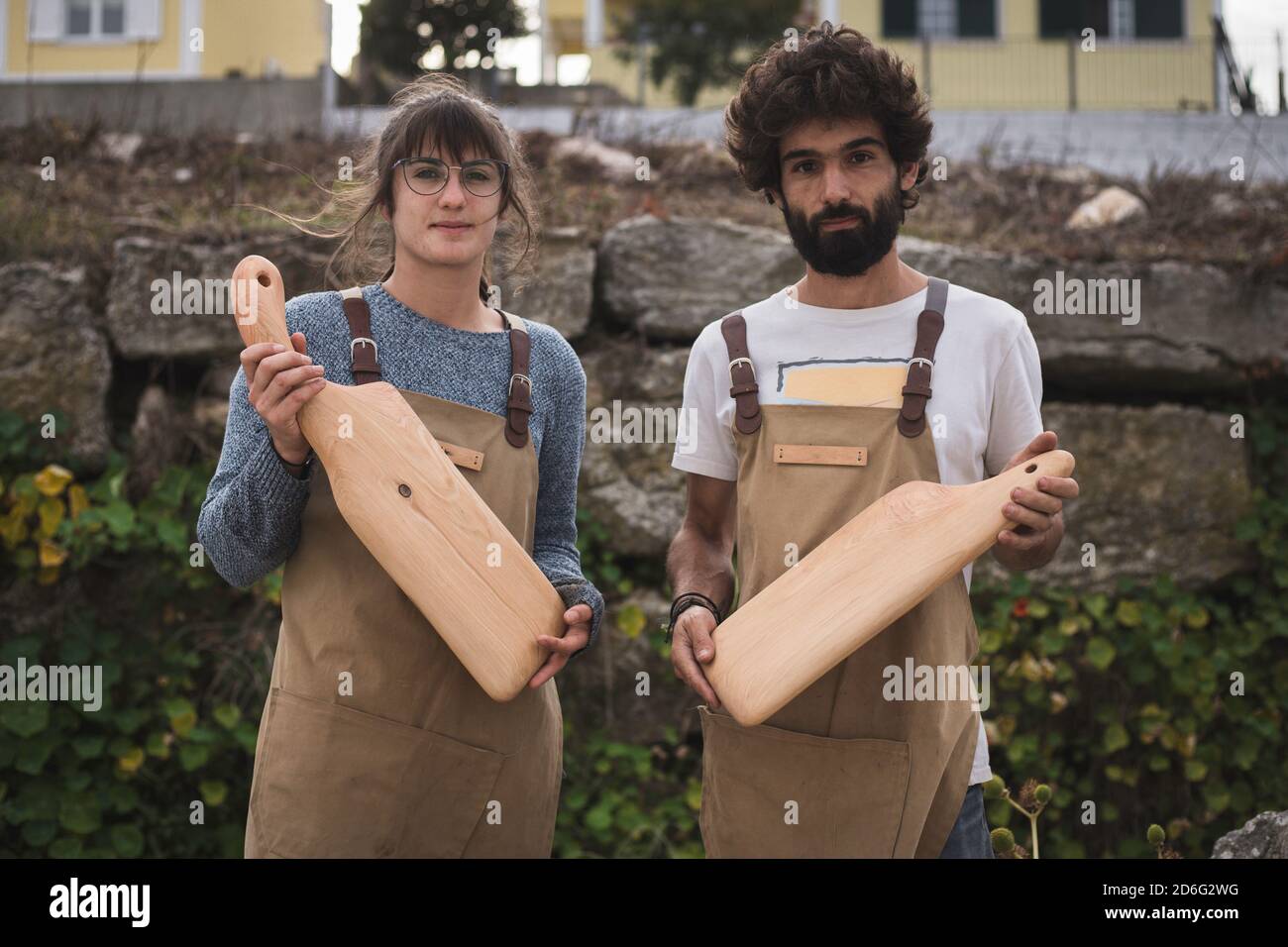 A young couple of carpenters working together in a small carpentry ...